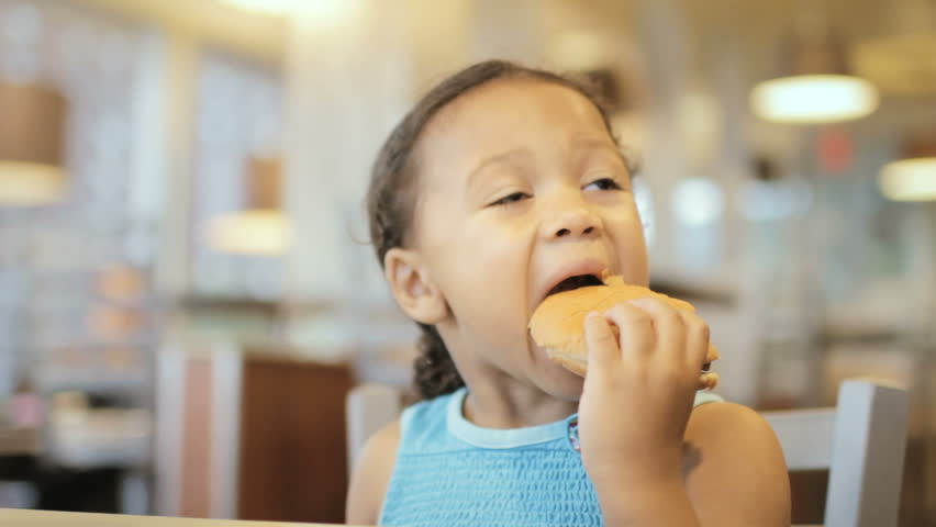 Stock video of child eating hamburger at fast food | 12072677 ...