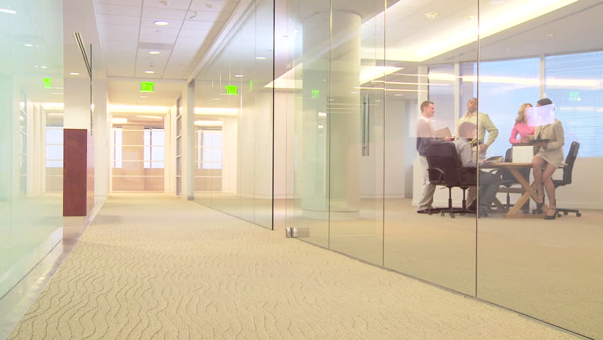 Group Of Business Professionals Walking Away Down Office Hallway Stock ...