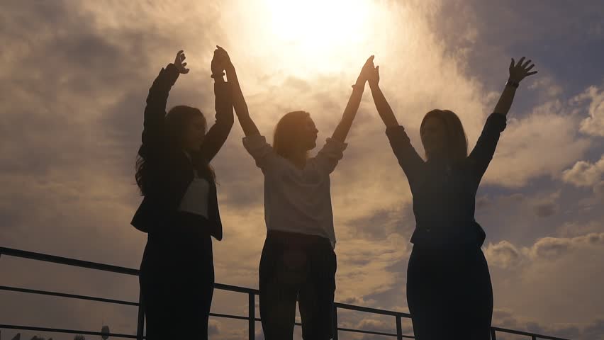 Silhouette Of A Group Of People Raising Their Hands Up Victory Over A ...