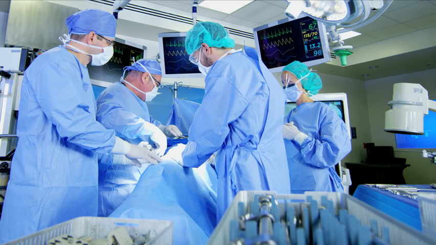 Medical Caucasian Male And Female Surgical Team In Scrubs Performing ...