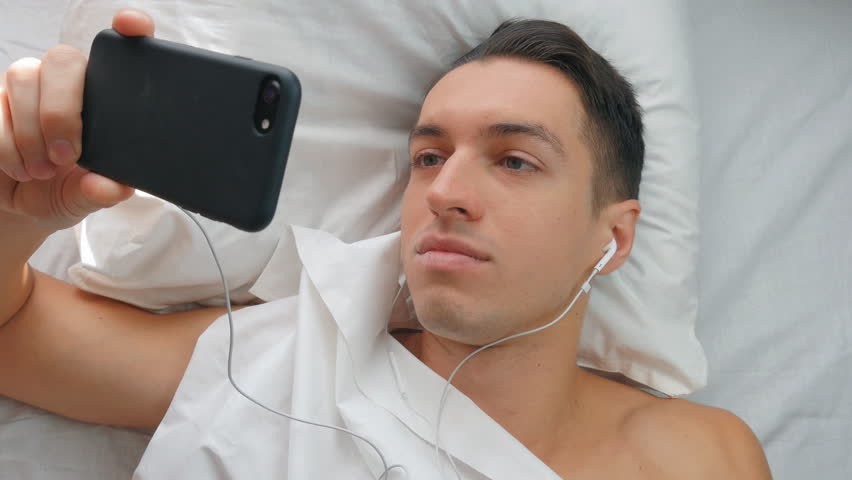 Man Watching Video On Smartphone While Lying On Bed At Morning Stock ...