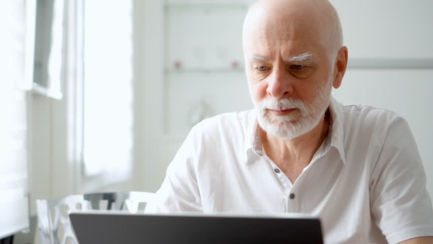 Stock Video Clip of Handsome elderly senior man working on laptop ...