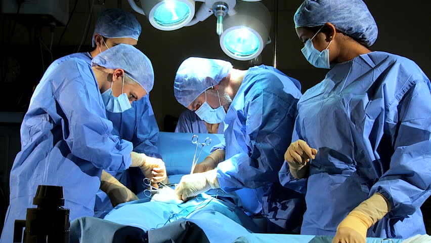 Senior Doctor Performing Operation Using Surgical Equipment Helped By ...