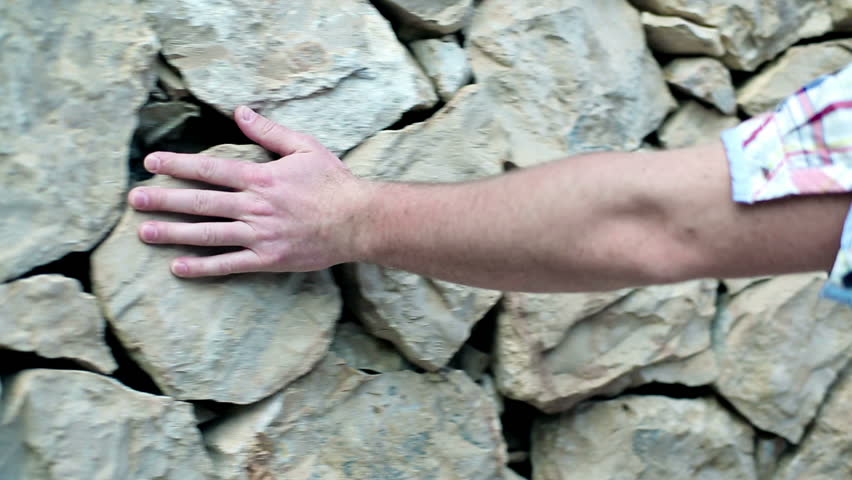 Stock Video Clip of Man hands touching stone wall, steadycam shot ...
