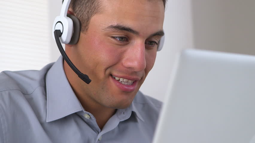 Stock video of smiling hispanic telemarketer working at computer ...