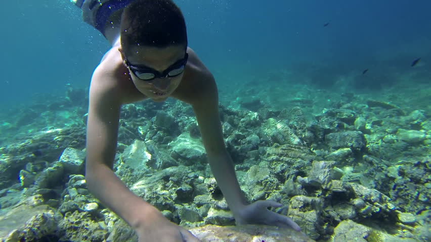 Teenager Swimming With Fishes. Underwater Shoot Of A Young Boy Doing ...