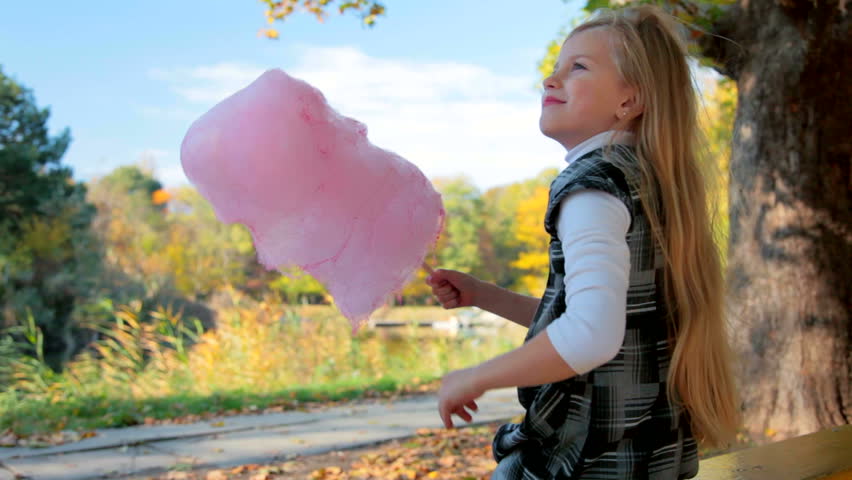 Stock Video Clip of Little girl eating cotton candy in | Shutterstock