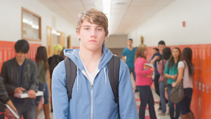 A Teacher Stands In A Busy Hallway With Students And Stares Into The ...